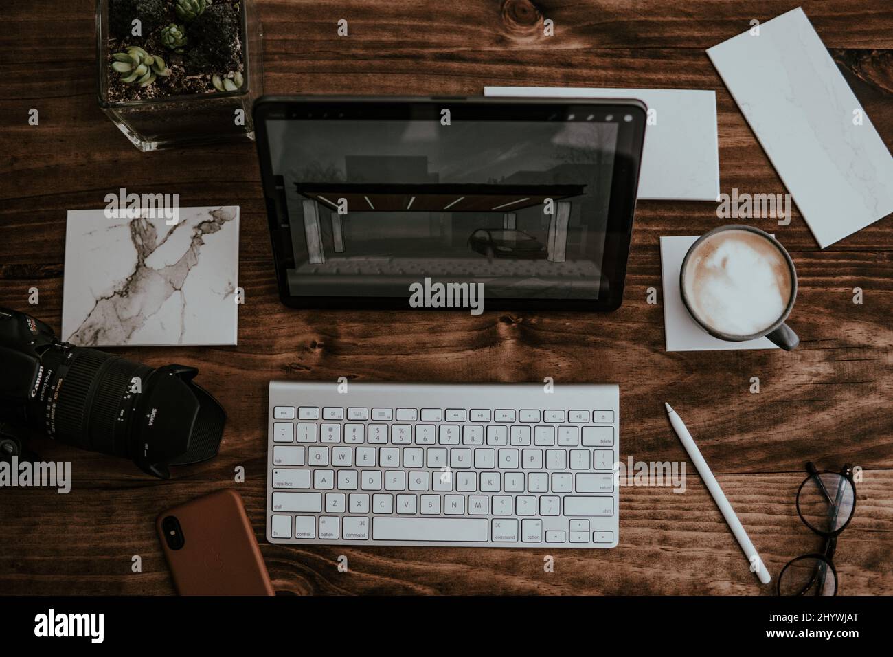 Top view of mug of Nescafe with computer and pen with camera on a table ...