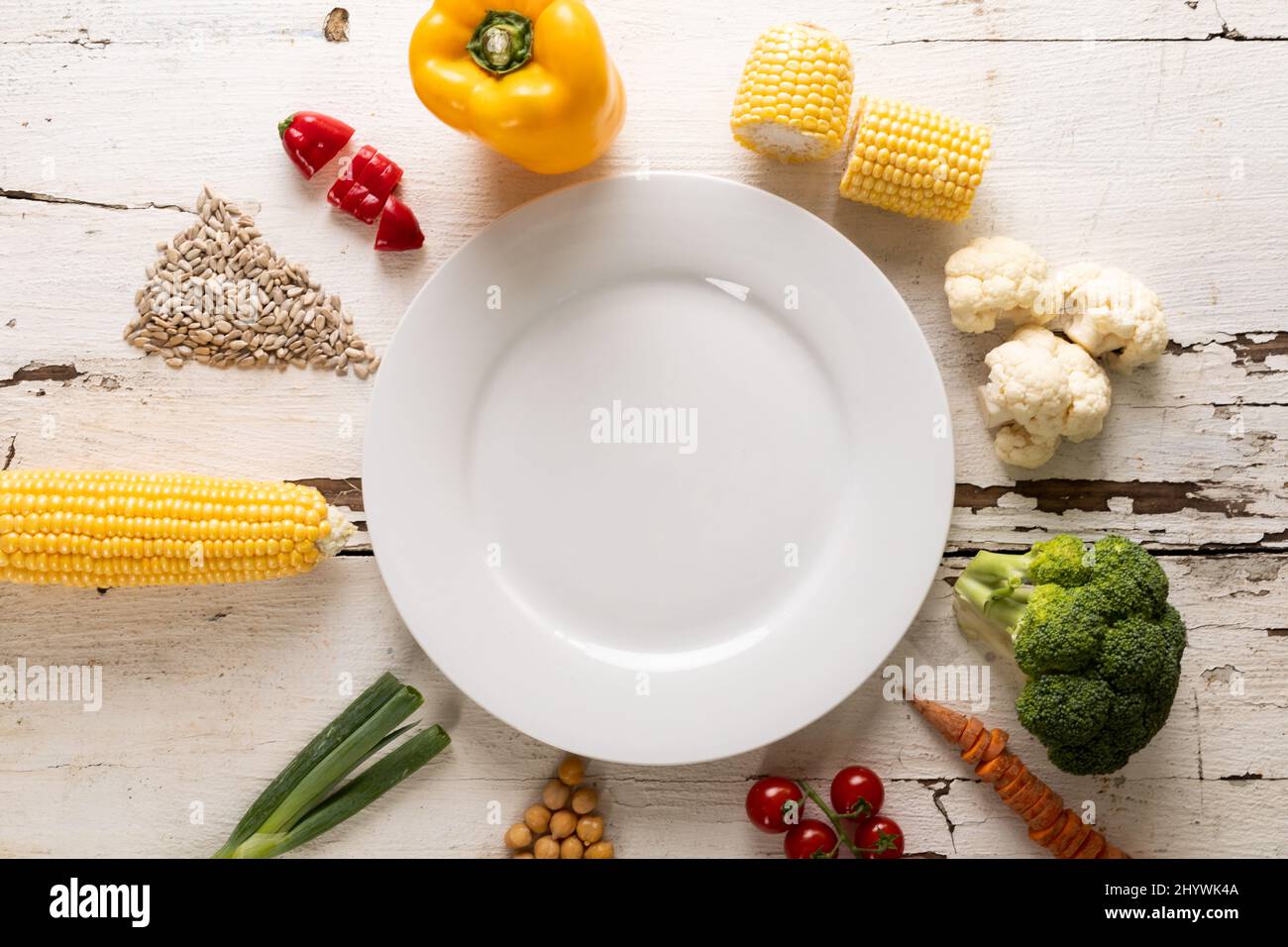 Overhead view of ingredients arranged around white empty plate on table ...