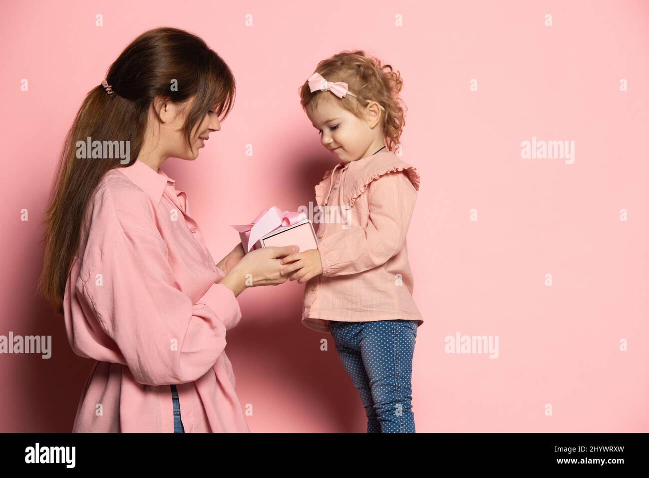 Delighted young woman and toddler, caring mother and daughter isolated ...