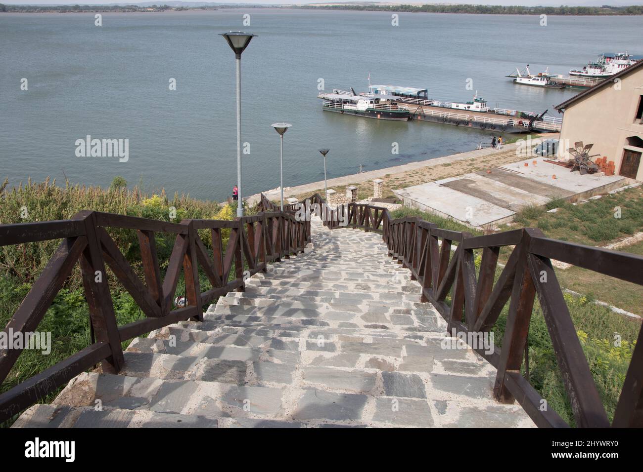 Scenic view of stairs with wooden handrails leading down to the sandy ...