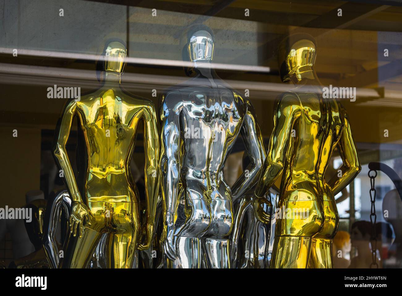 Close-up of shiny silver and gold mannequins in a shop window Stock ...