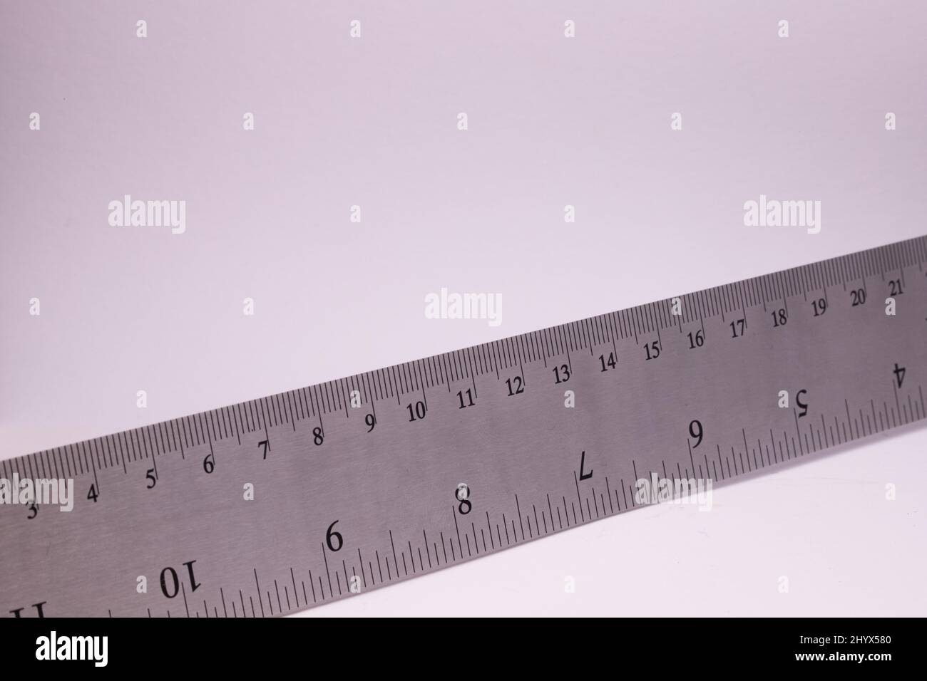 Steel ruler with inches and centimeters isolated on a white background ...