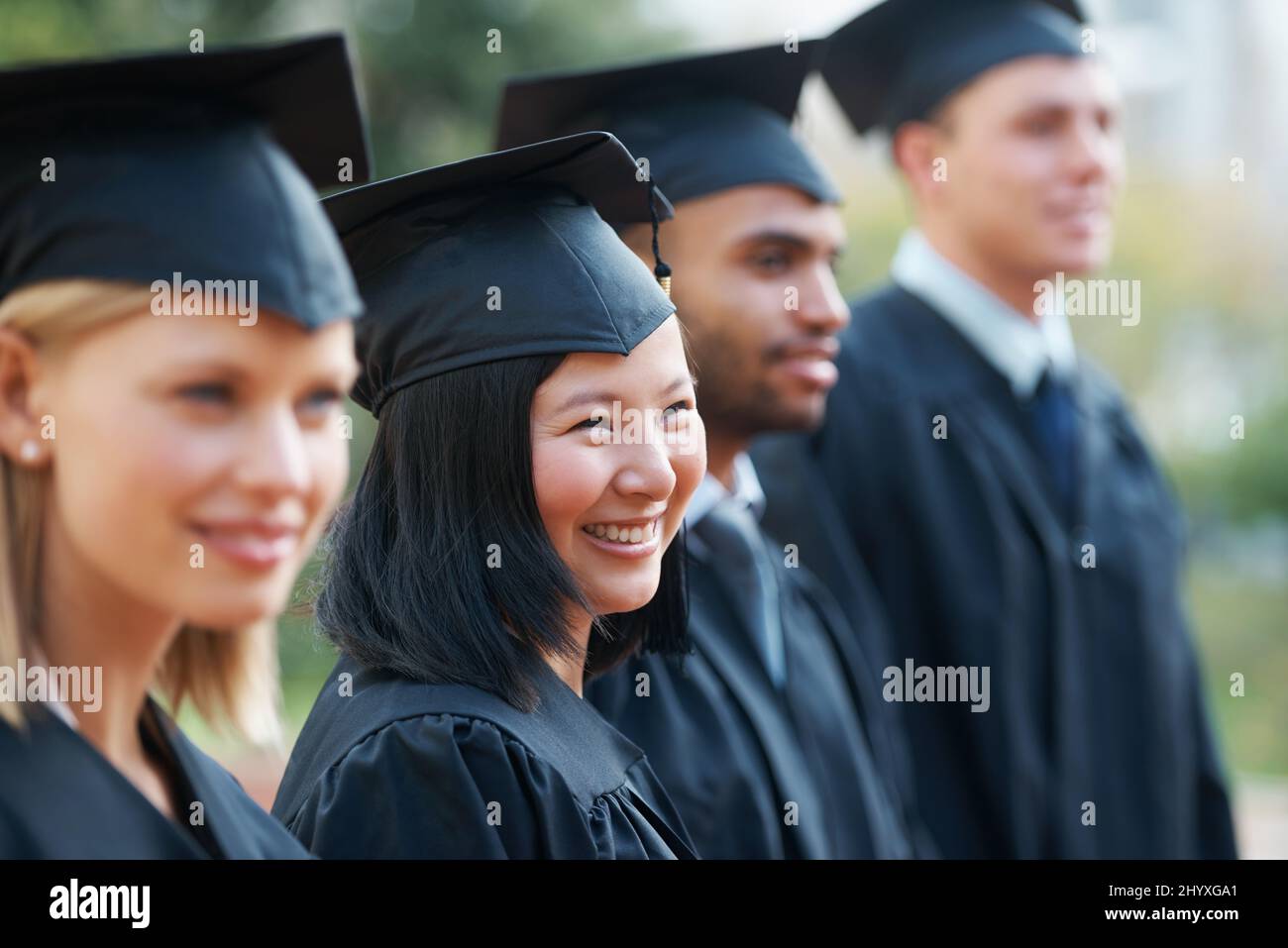 Looking forward to their future. Young college graduates holding their ...