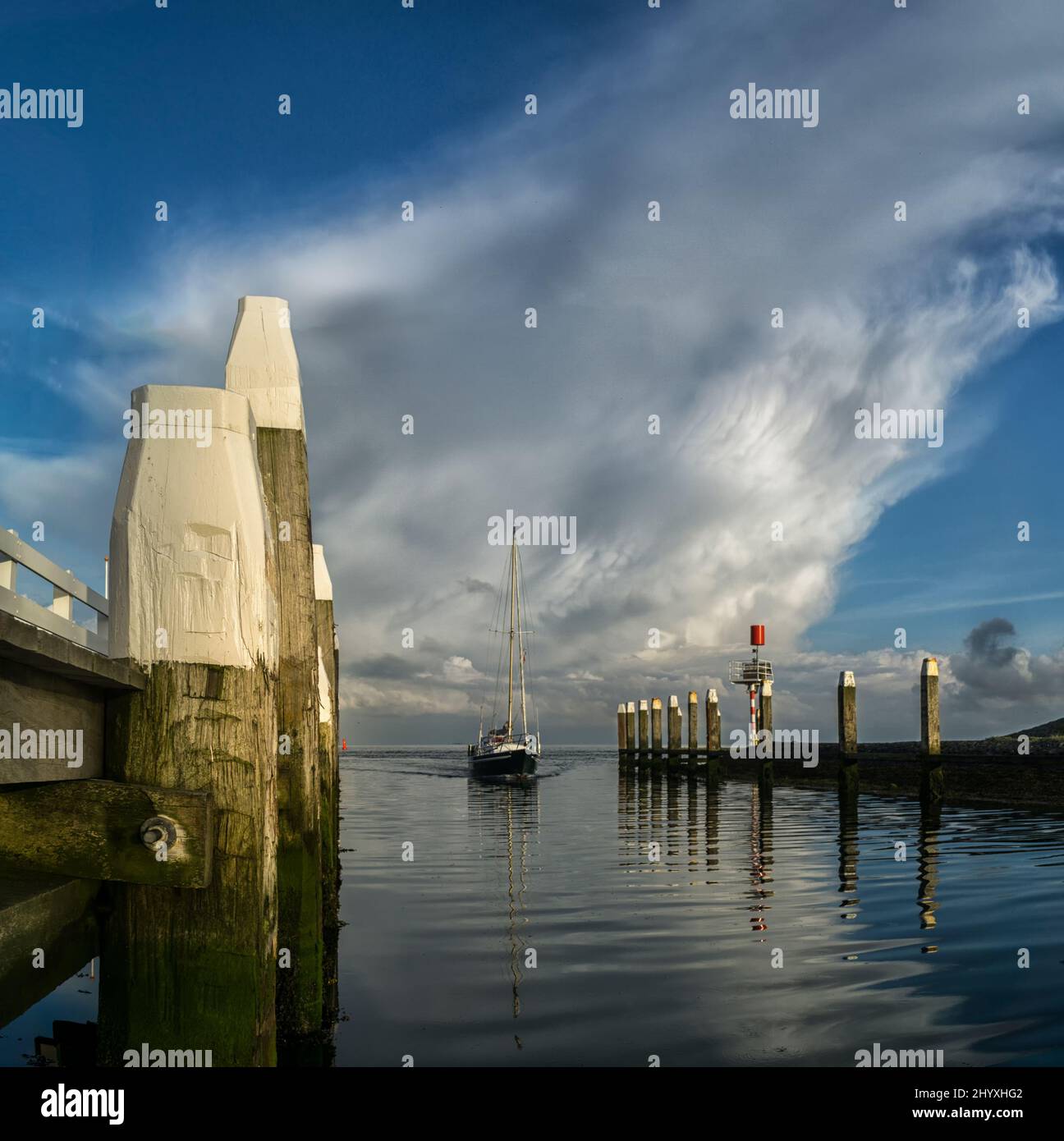 Low angle shot of a sail boat on the water coming towards a harbor with ...