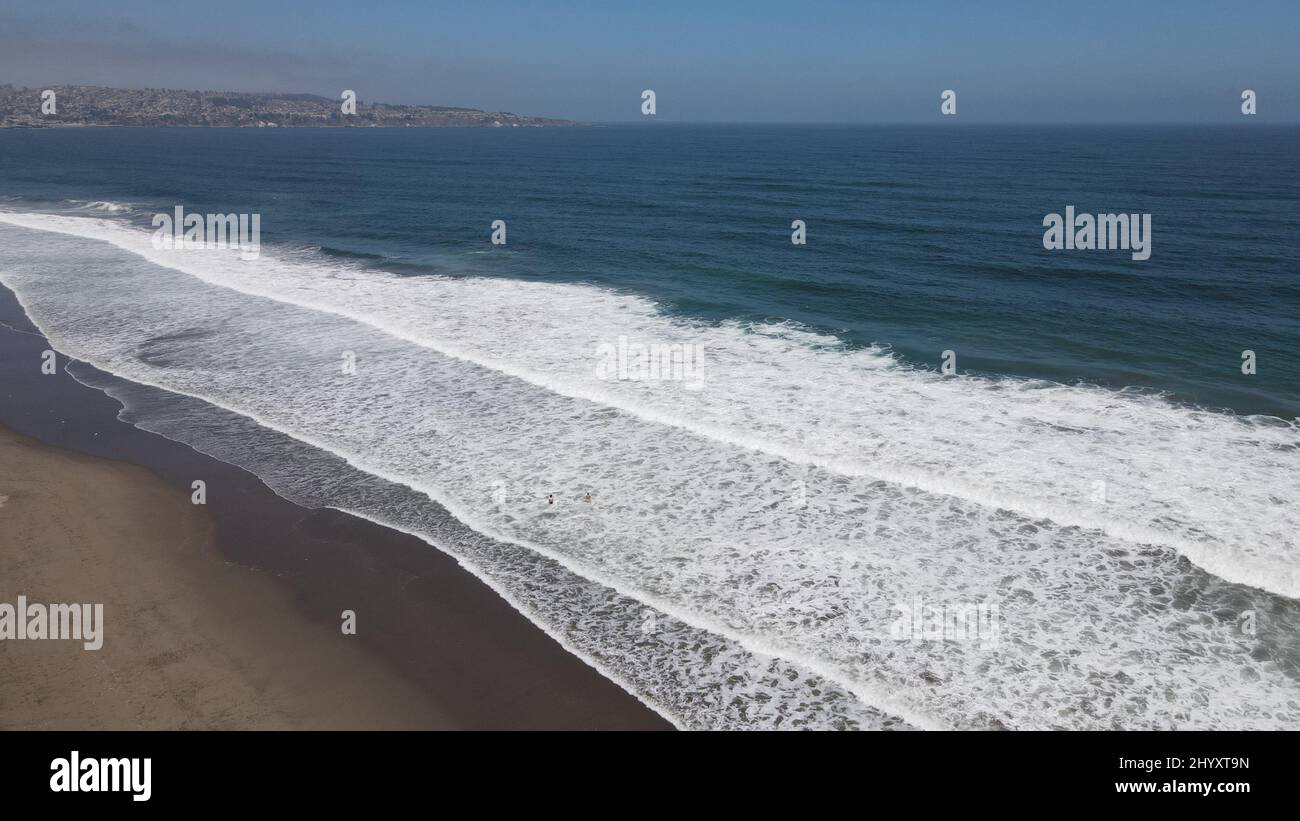 Aerial view of the wavy sea hitting the sandy beach on the coast Stock ...