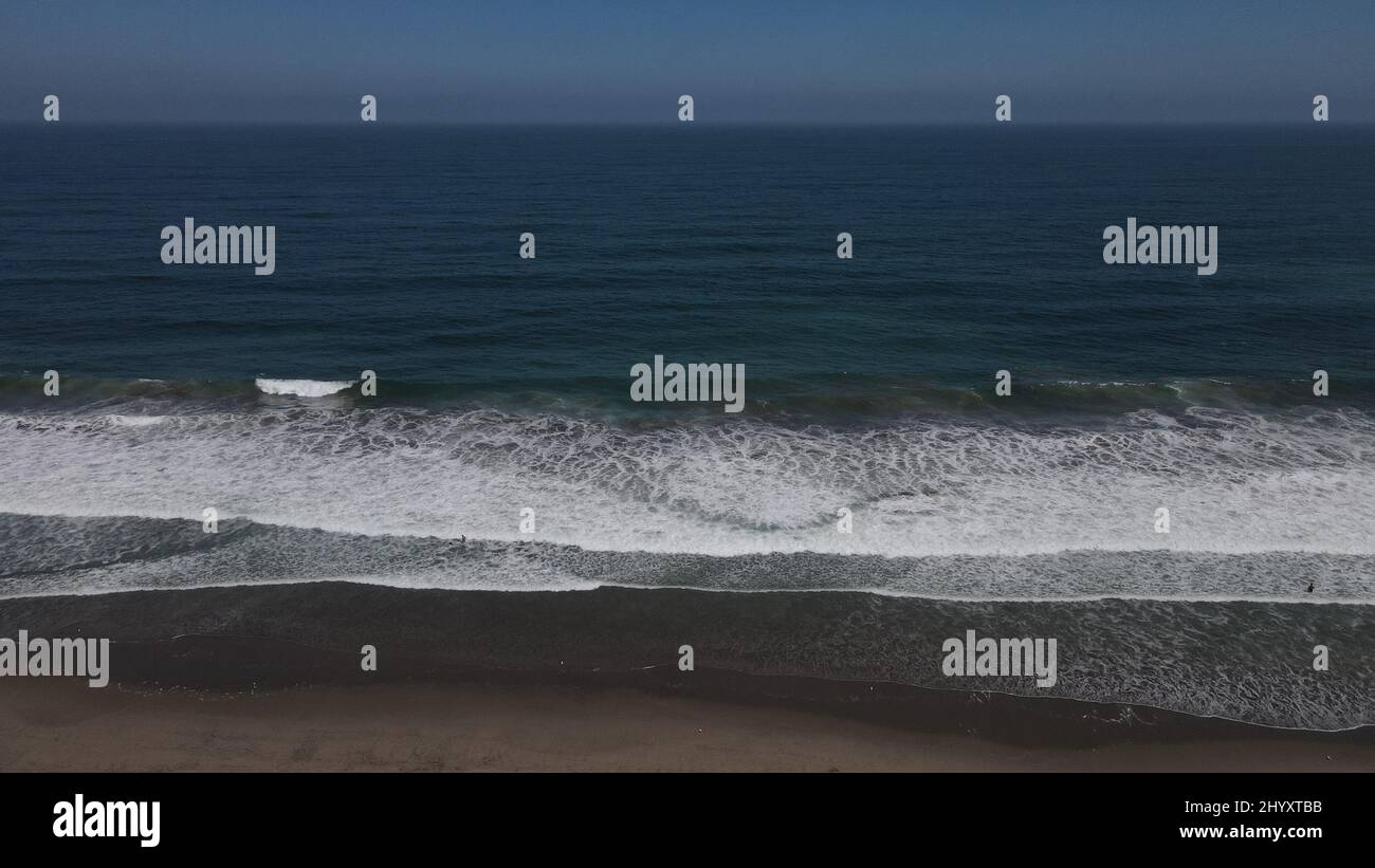 Aerial view of the wavy sea hitting the sandy beach on the coast Stock ...