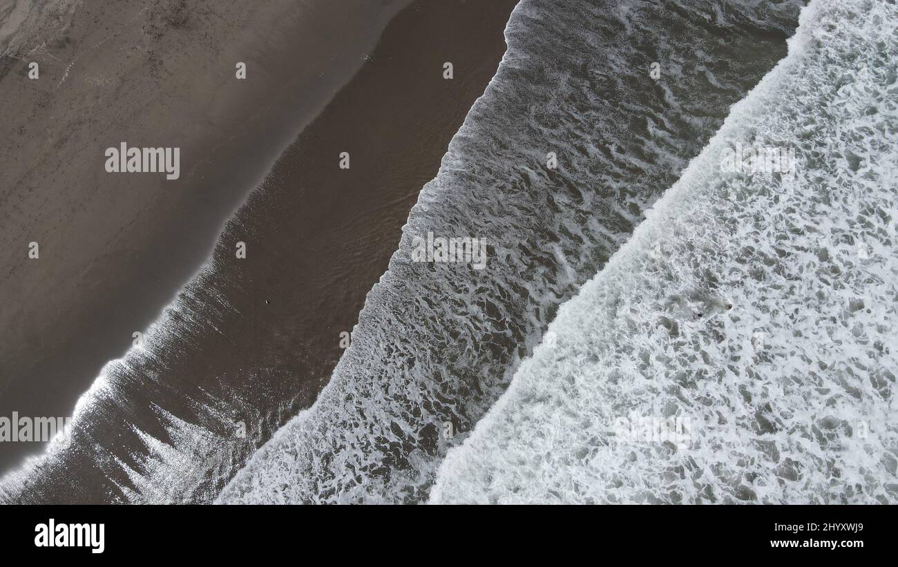 Aerial view of the wavy sea hitting the sandy beach on the coast Stock ...