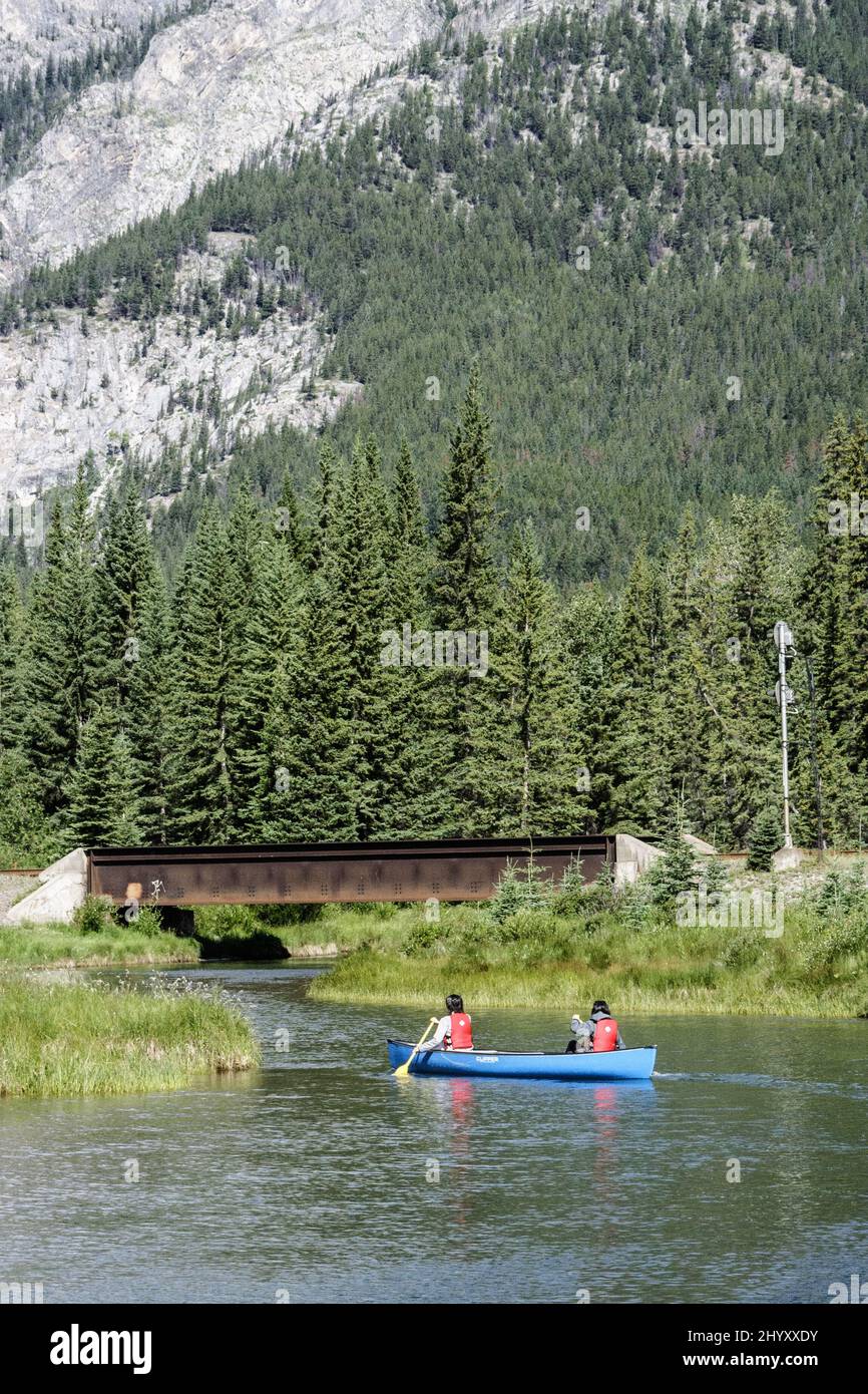 Two people in a canoe paddle down the Bow River in Banff, Alberta ...