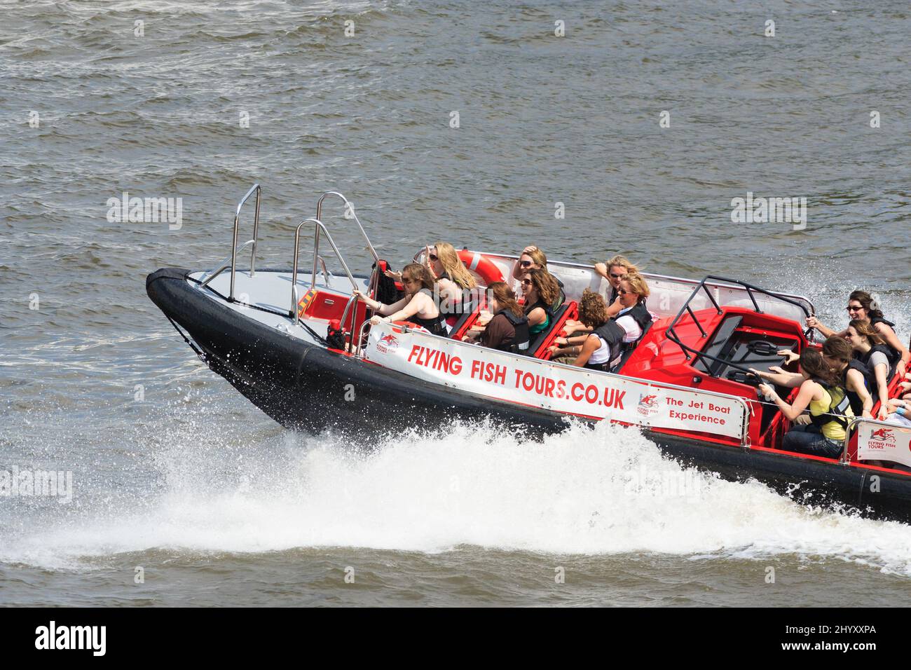 Passengers on a speed boat enjoy a fast ride on the River Thames in ...