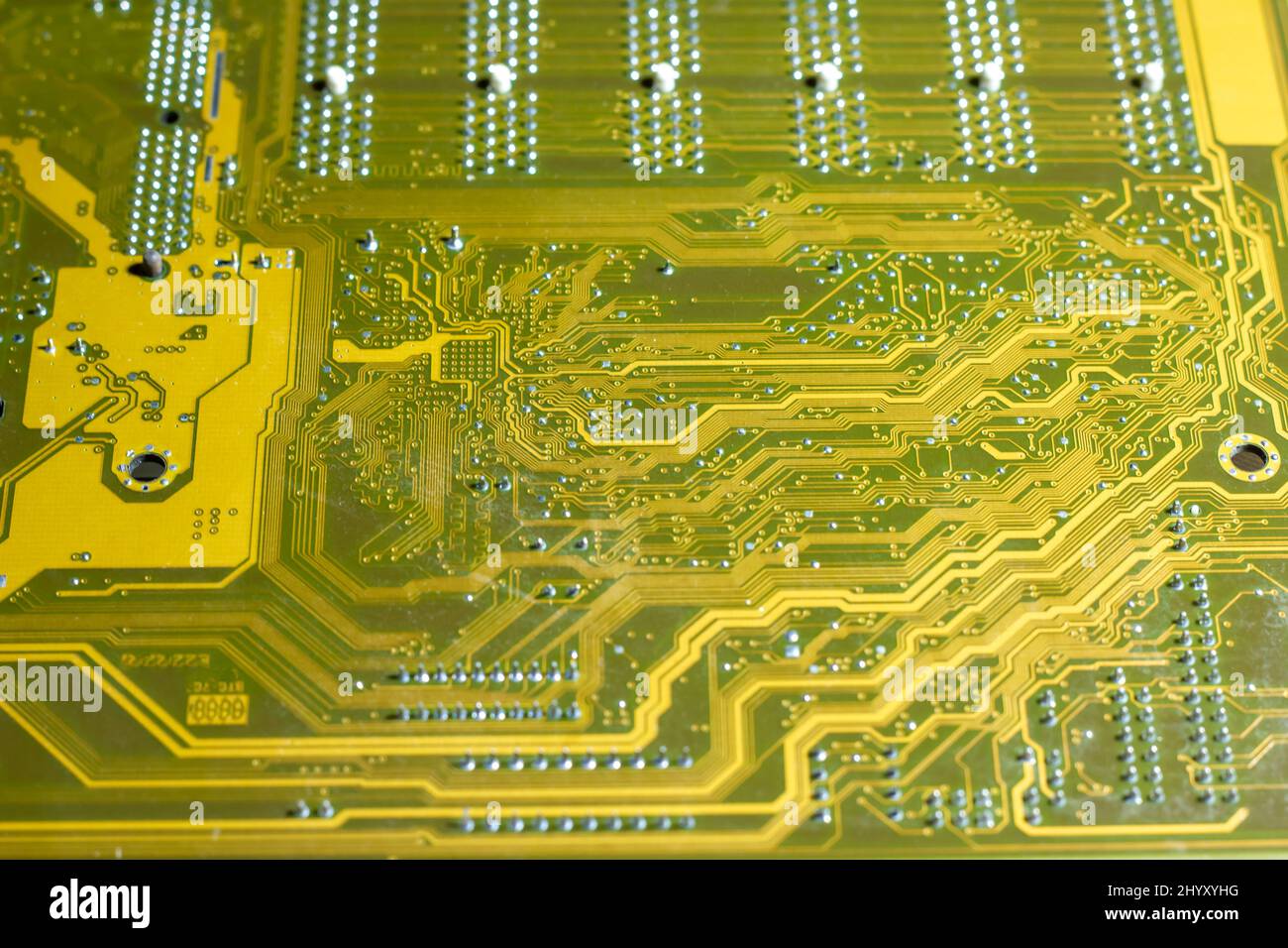 Closeup of a yellow printed circuit board with integrated circuit with ...