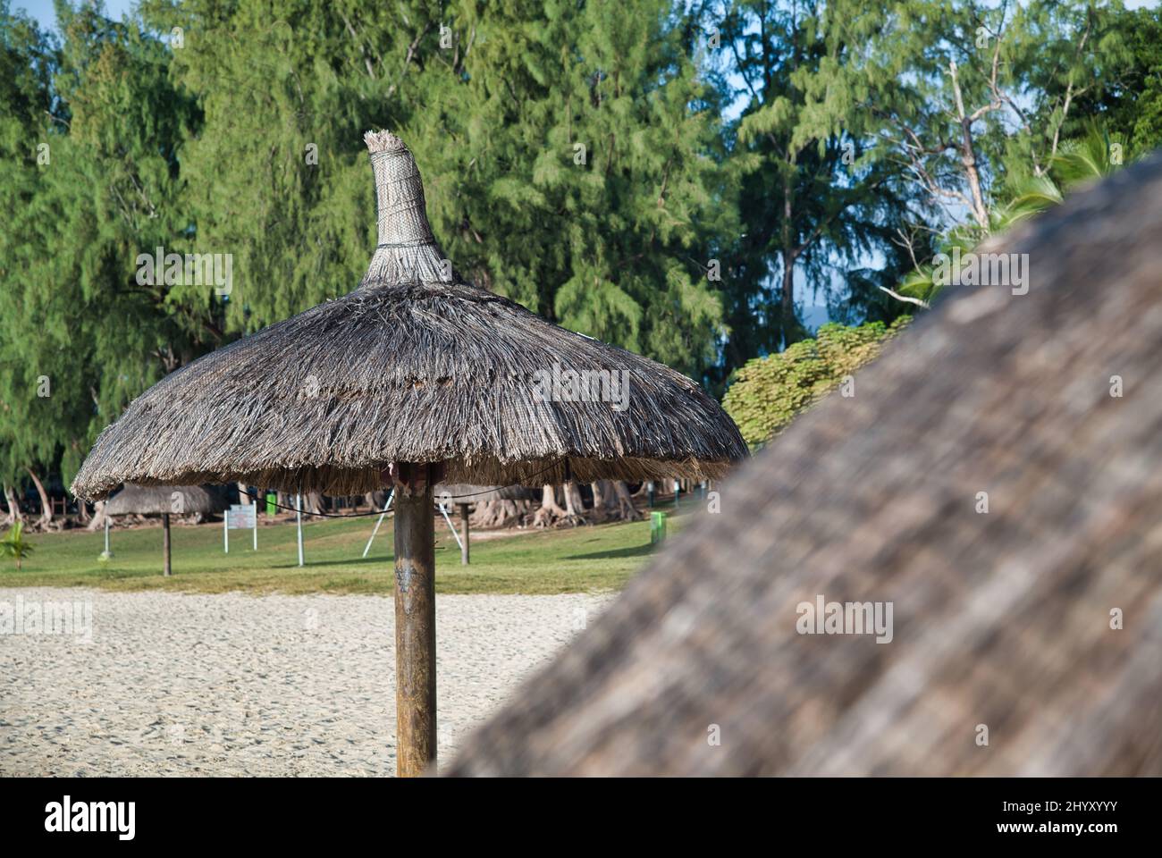Straw beach umbrella on a beautiful beach Stock Photo - Alamy