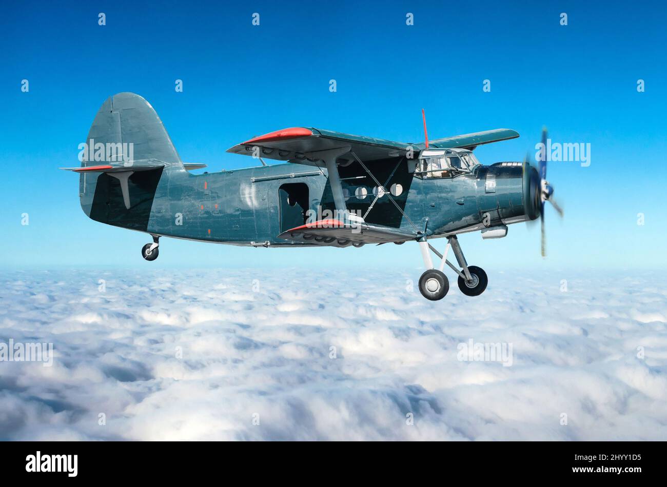 Aircraft turboprop biplane at high altitude in the sky above overcast ...