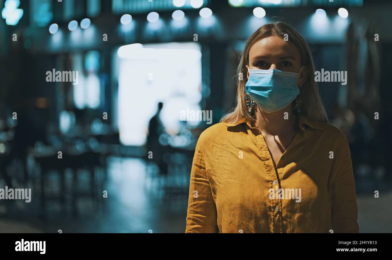Woman putting on a medical mask on the street. Wear mask in public ...