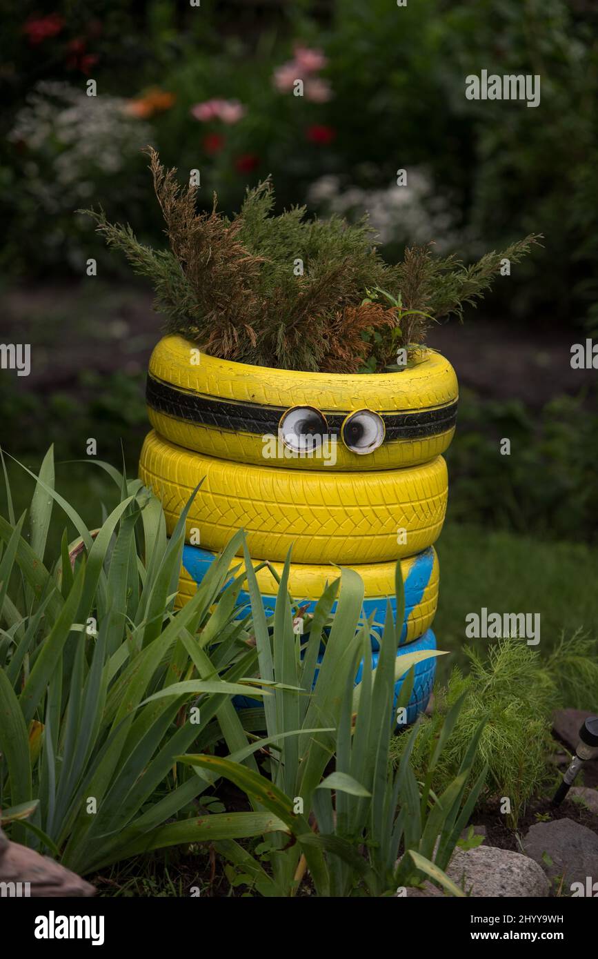 Vertical shot of a build minion flower planter made out of tires Stock ...