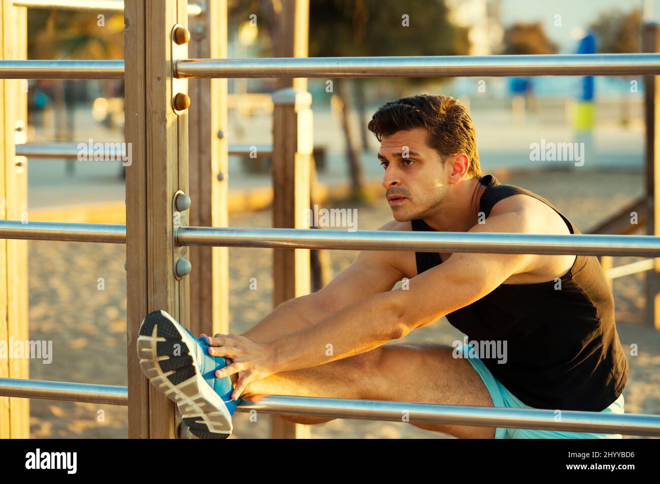 Man doing stretching workout on fitness station Stock Photo - Alamy