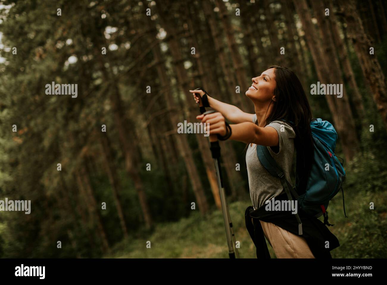 Pretty young female backpacker woman enjoying green beautiful forest ...
