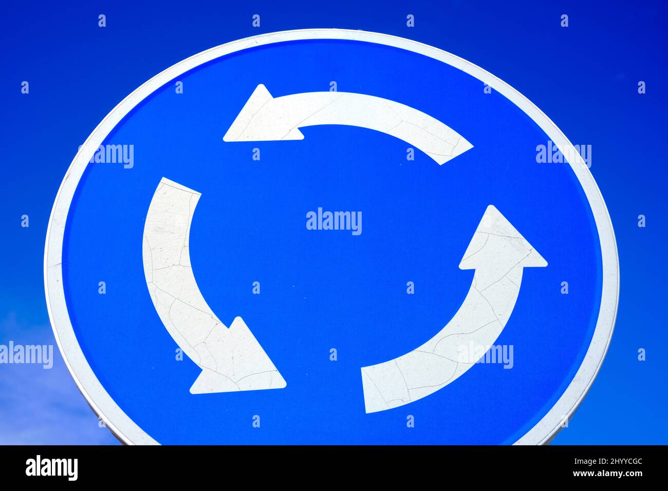 roundabout traffic sign with blue sky background Stock Photo - Alamy