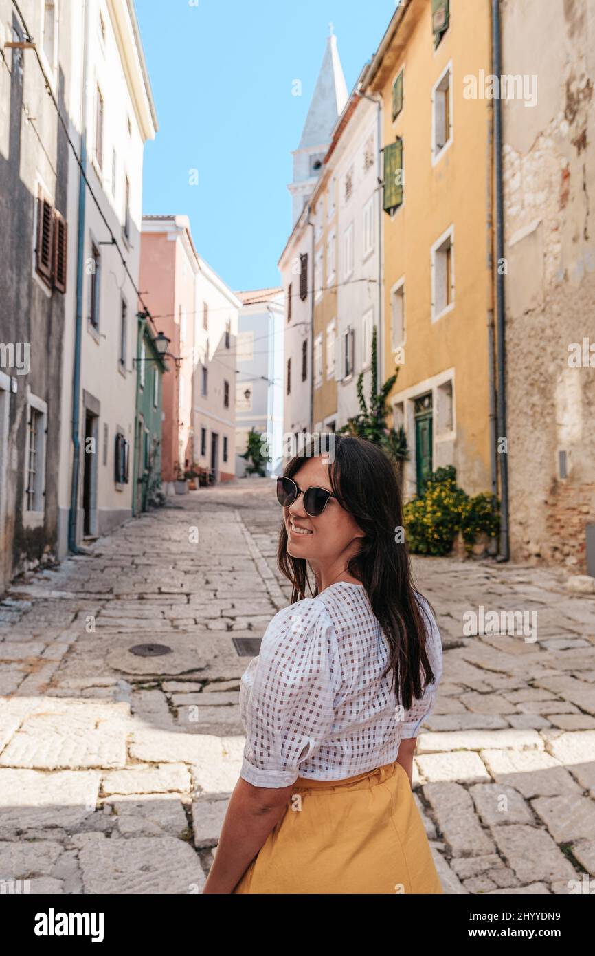 Vertical rear view of a young woman smiling and looking back at the ...