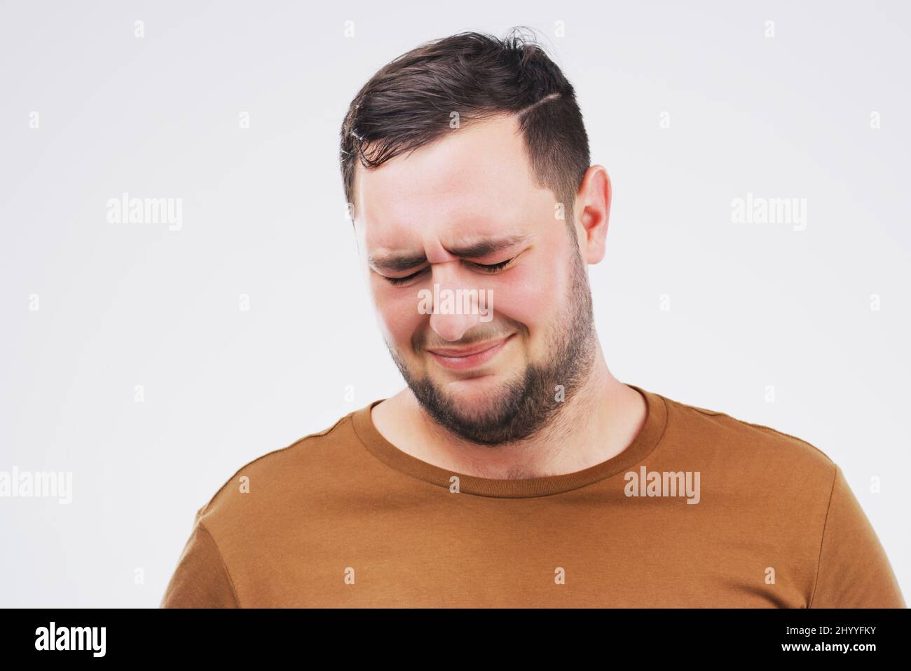 She broke my heart. Studio shot of a young man crying while standing ...