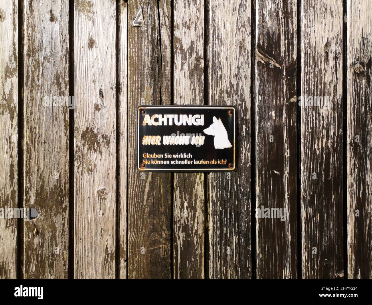 Warning sign on a wooden fence Stock Photo - Alamy