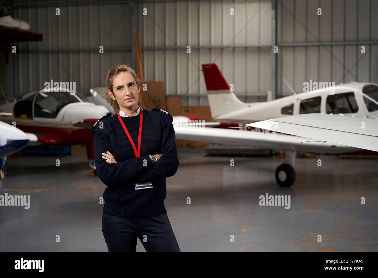 Young pilot posing in the hangar surrounded by airplanes Stock Photo ...