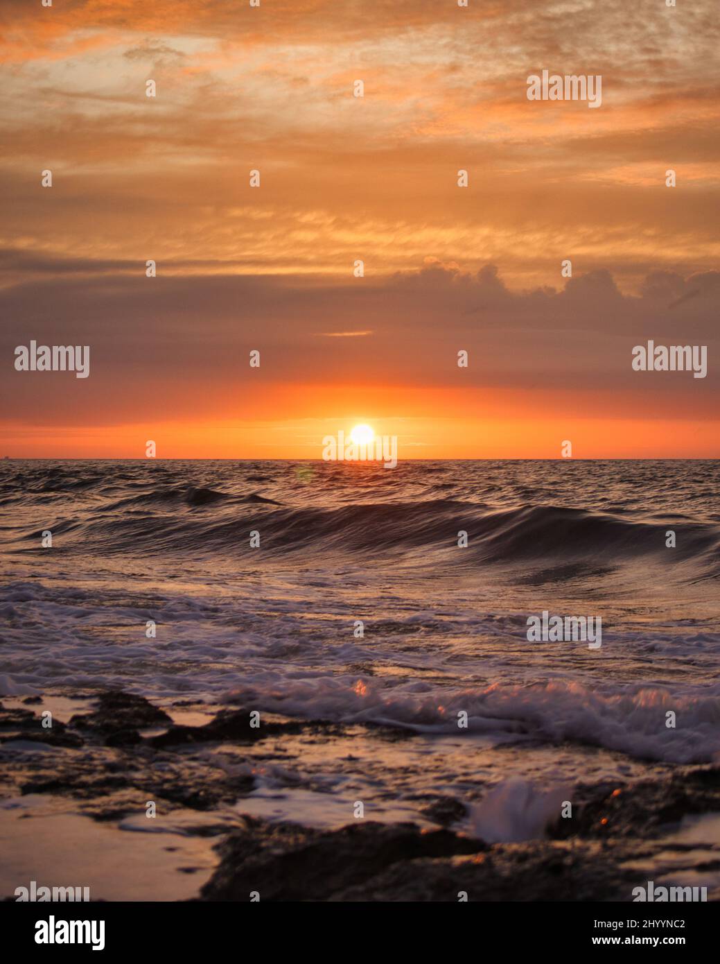 Vertical shot of a beautiful sunset over the ocean on the Isle of Wight ...