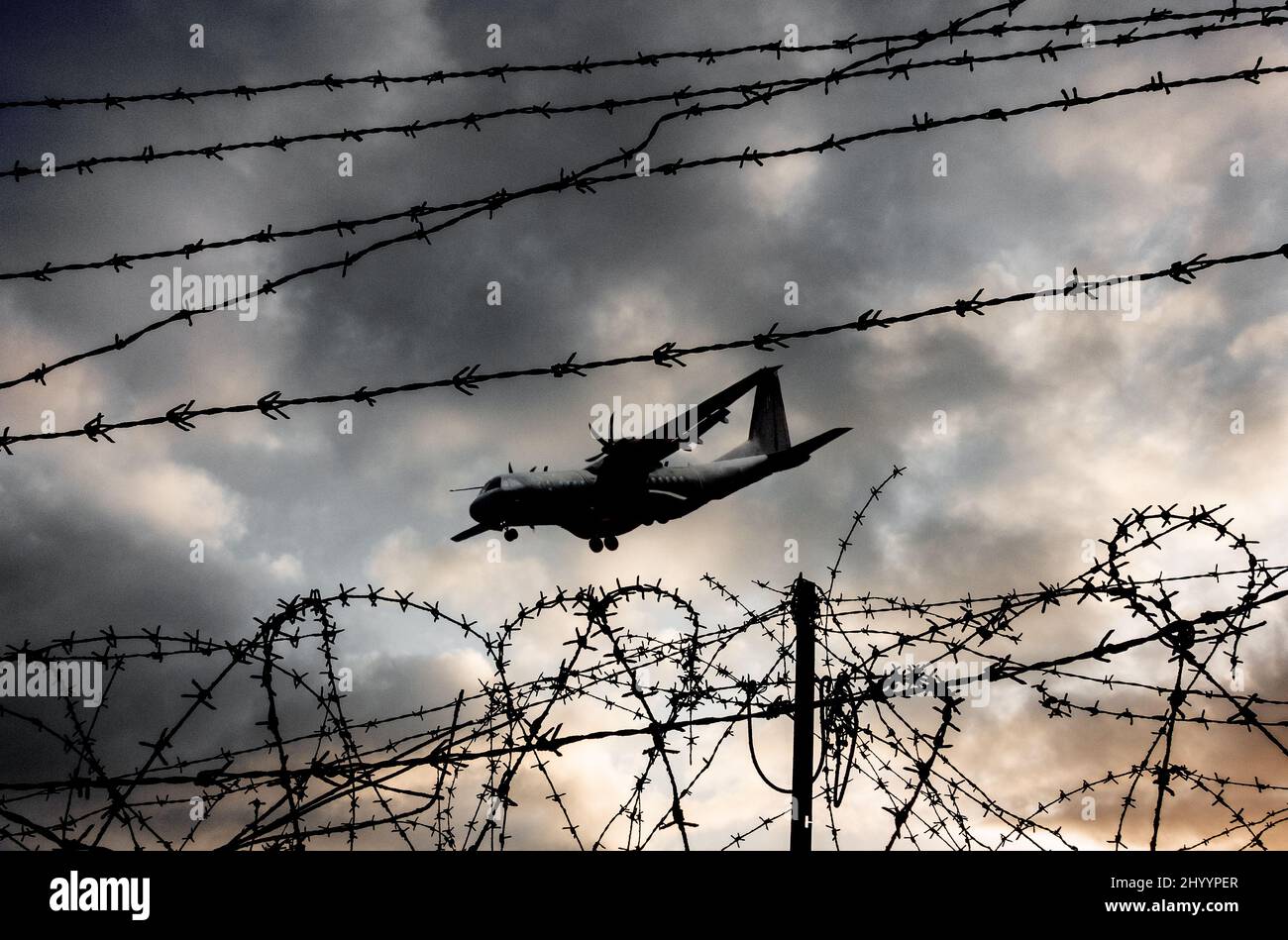Airplane, aircraft seen through barbed wire border fence. Concept image ...