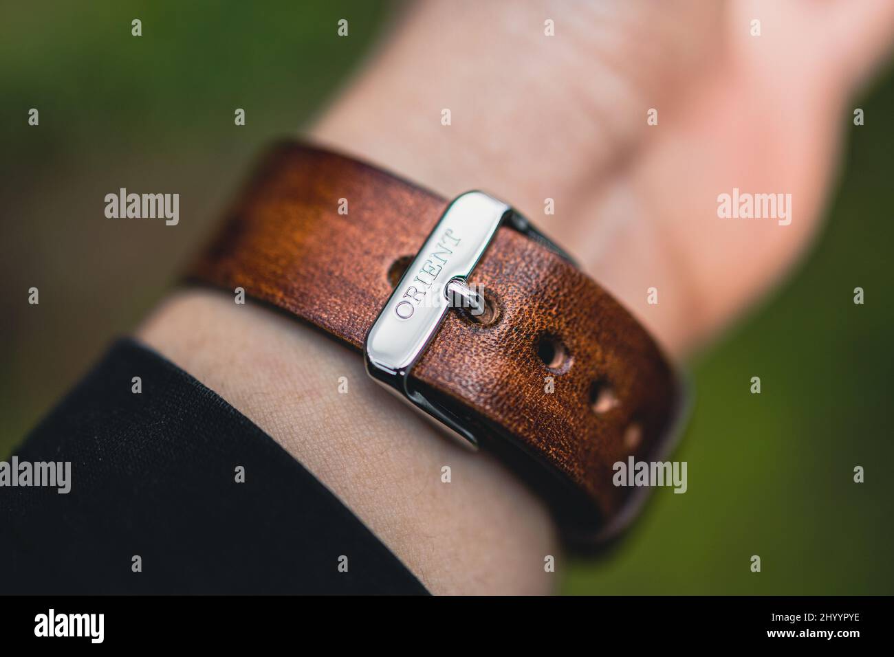 Closeup shot of the Orient watch strap on the wrist of the male against ...