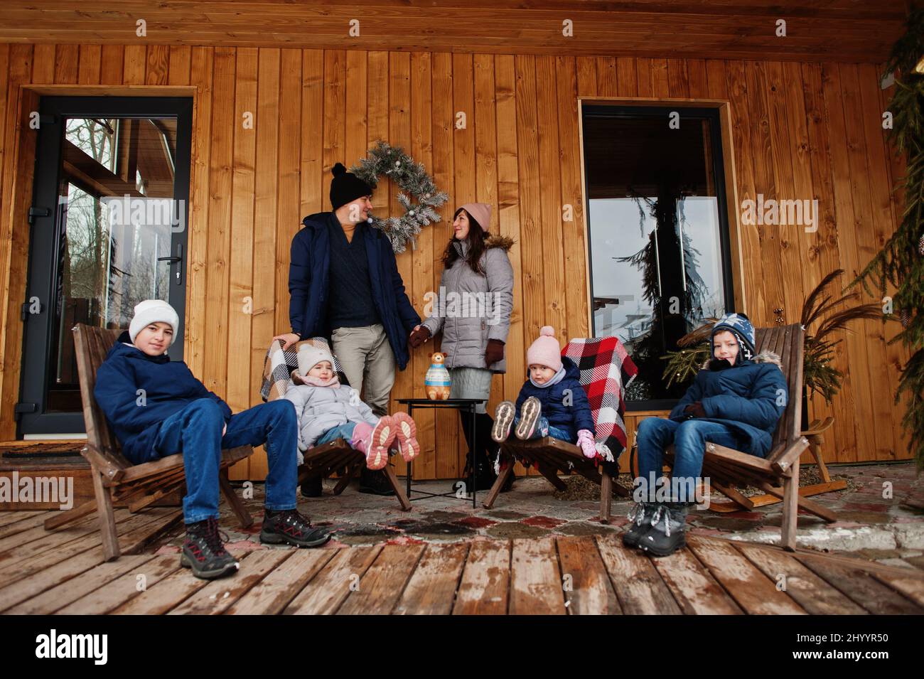 Big young family with four kids on the terrace of a wooden house in ...
