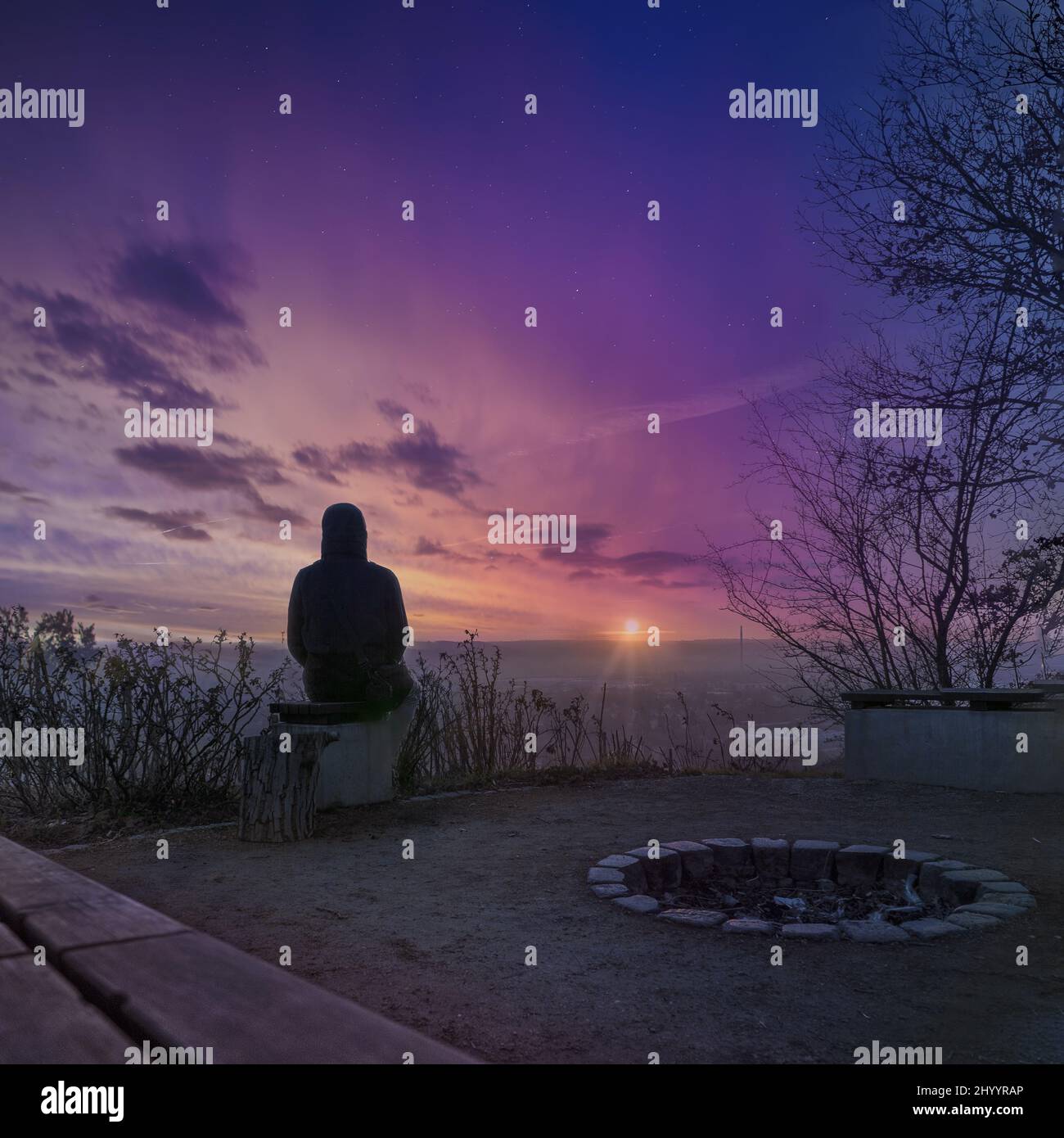 Low angle shot of a person sitting on a bench looking out into the ...