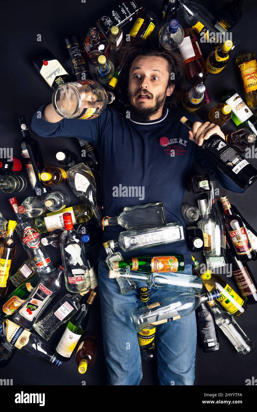 Top view of a male lying surrounded by bottles of alcohol Stock Photo ...
