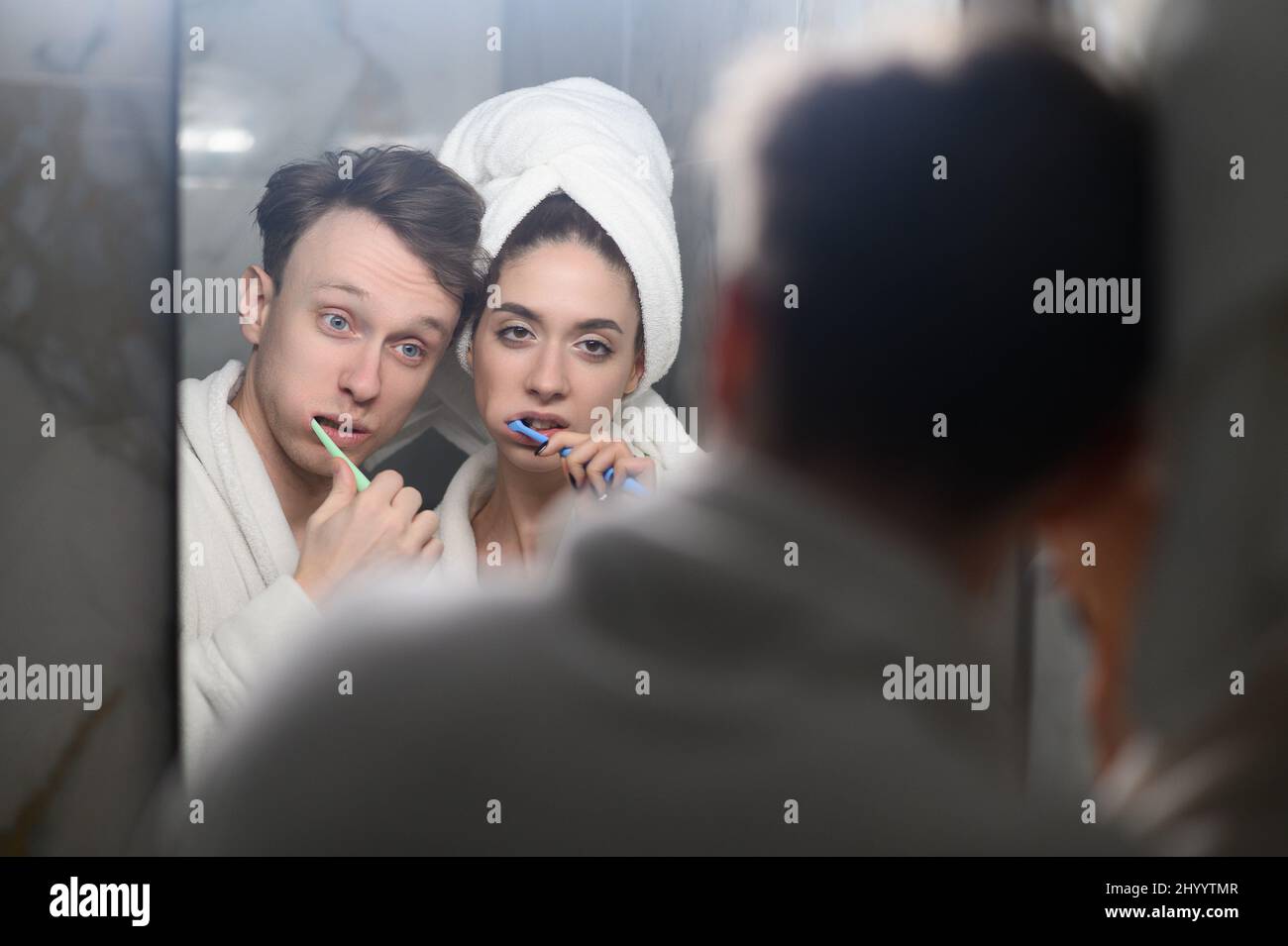 a young married couple brushing their teeth together. Dental hygiene ...