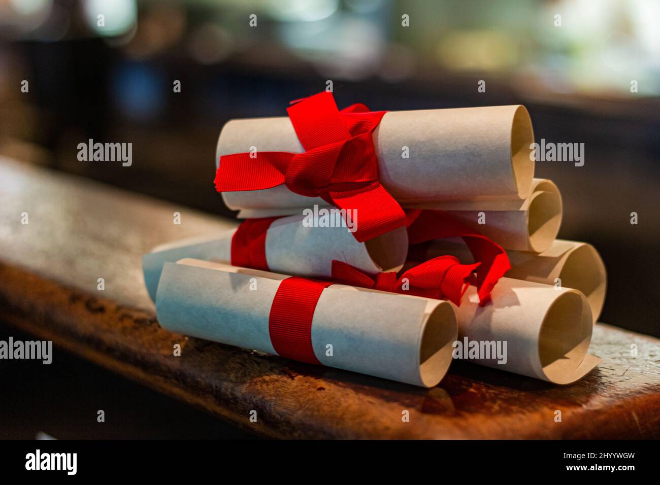 Group of white scrolls wrapped with red ribbon stacked together on a ...