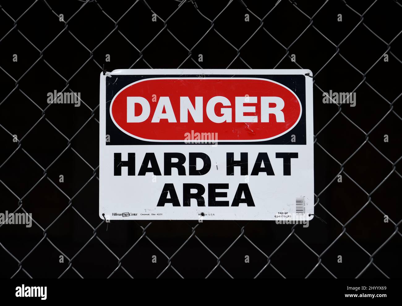 A "Danger" sign on a chainlink fence surrounding a construction site in ...