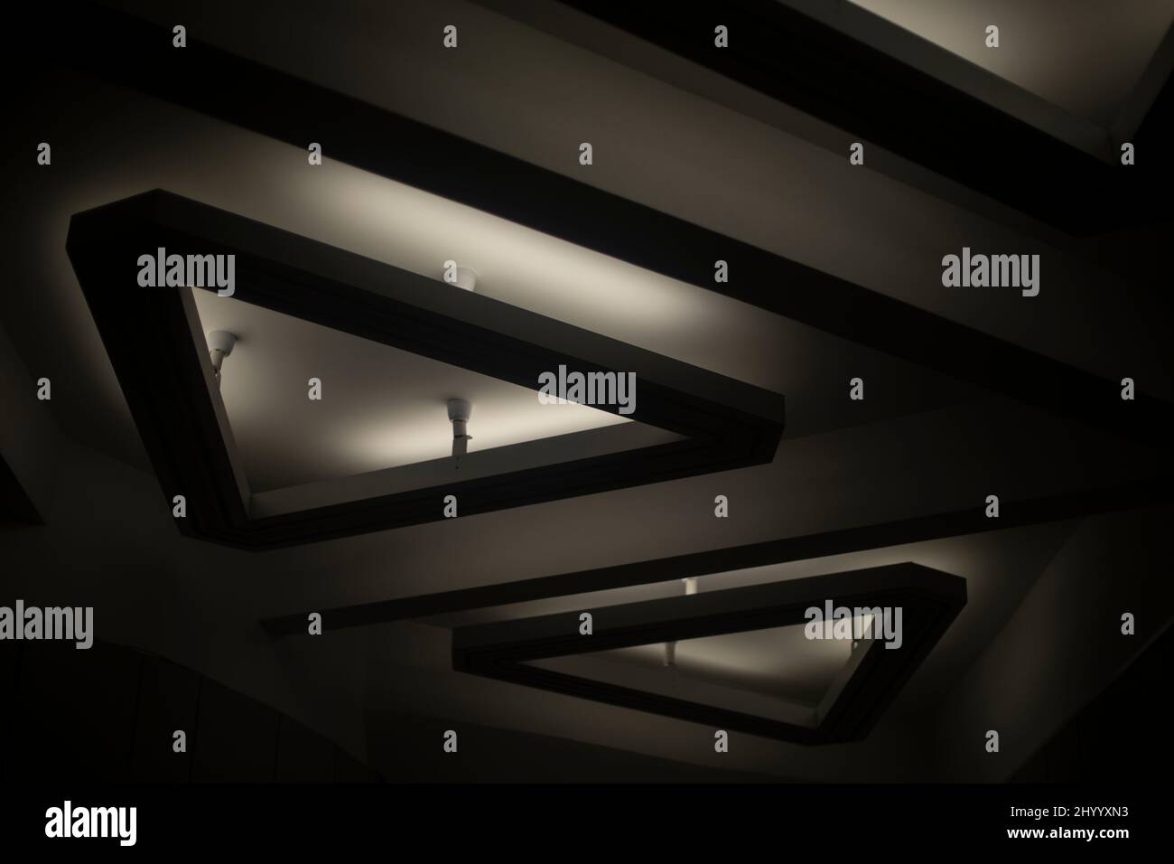 Triangular lamp on ceiling. Interior details. Light in hall. Luminaire ...