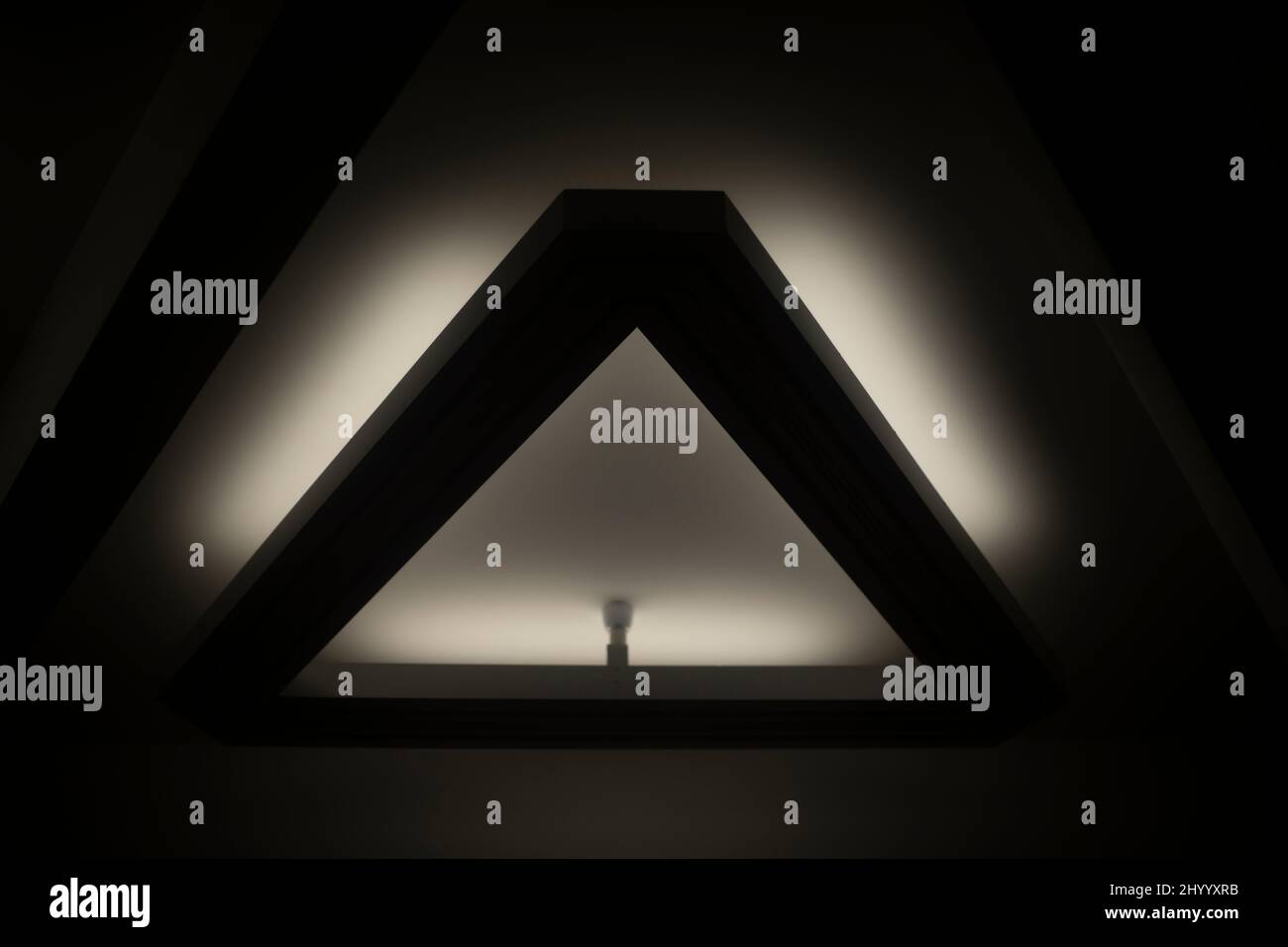 Triangular lamp on ceiling. Interior details. Light in hall. Luminaire ...