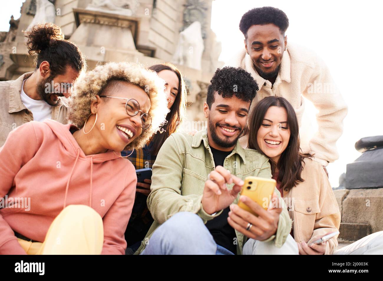 Group of people watching video on the mobile phone. Smiling friends ...