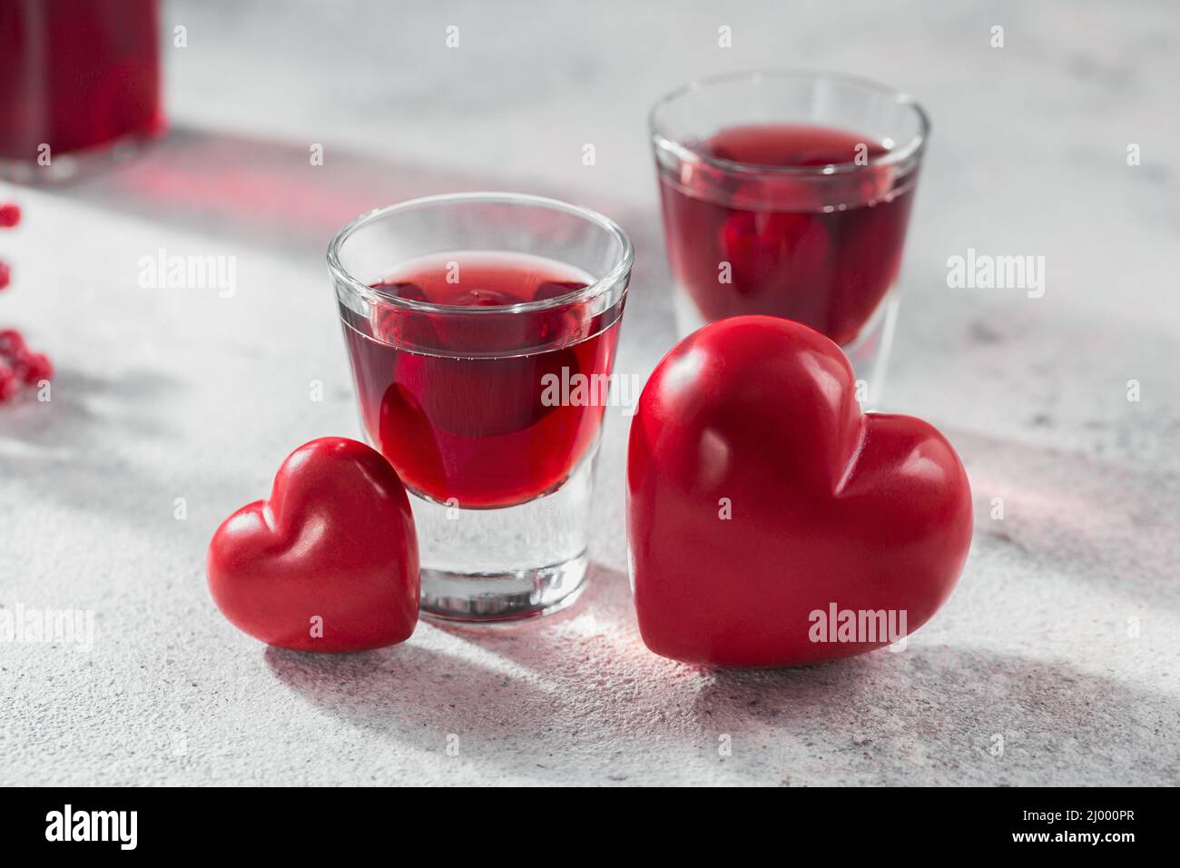 Red cocktail, vodka or liqueur and Heart shape decorations on white ...