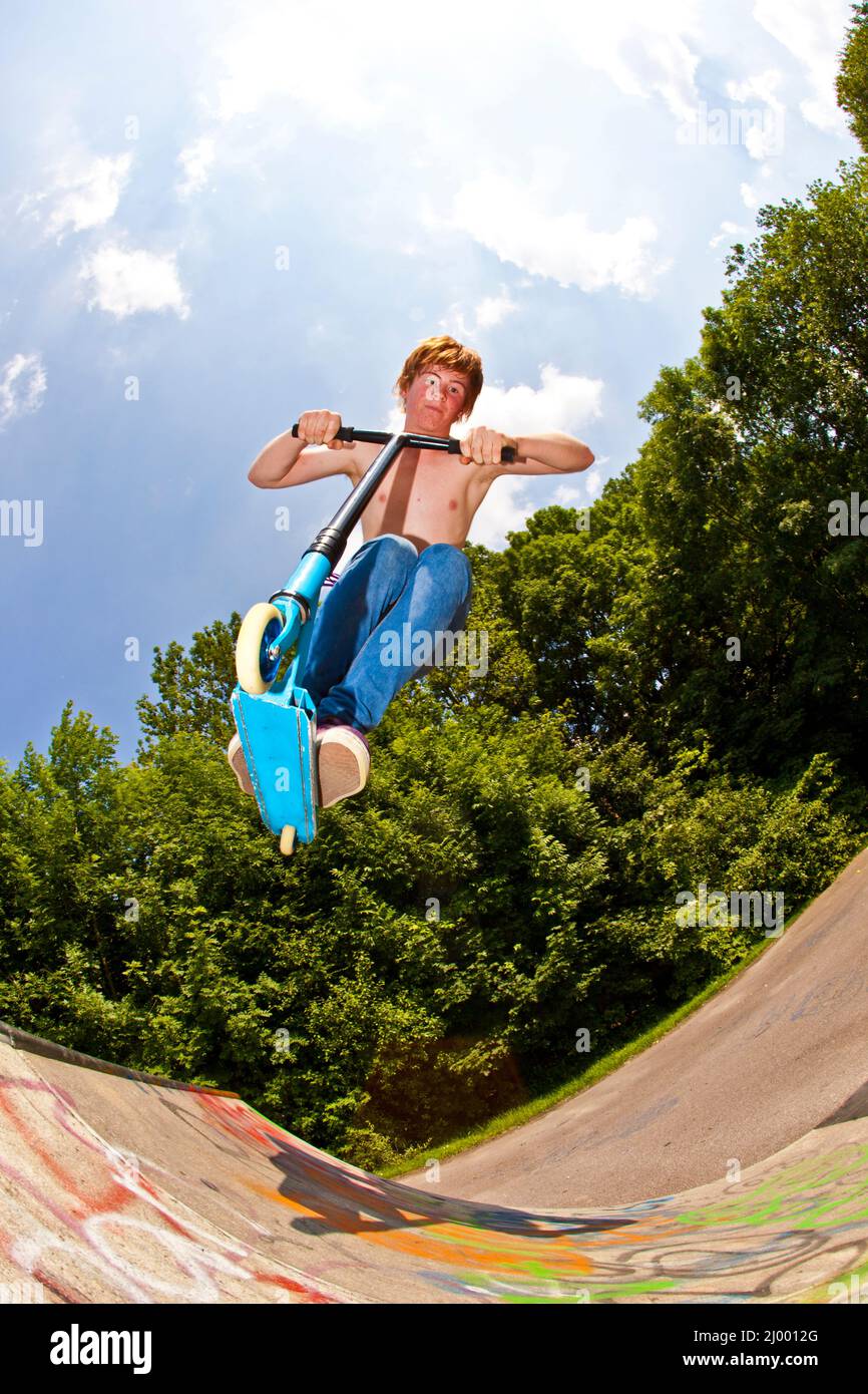 young boy going airborne with his scooter Stock Photo - Alamy