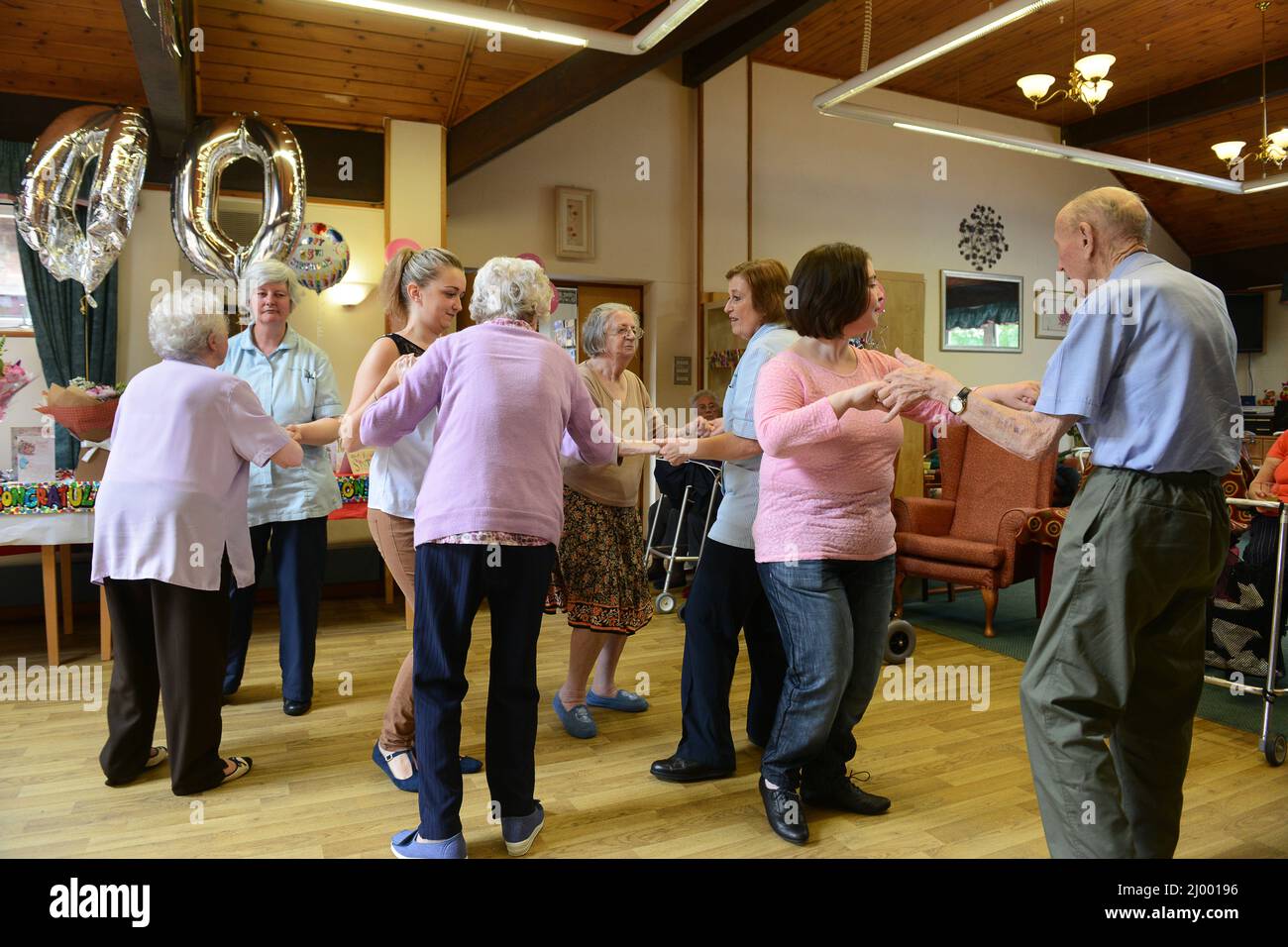 Care home residents dancing with staff and friends at care home Britain ...