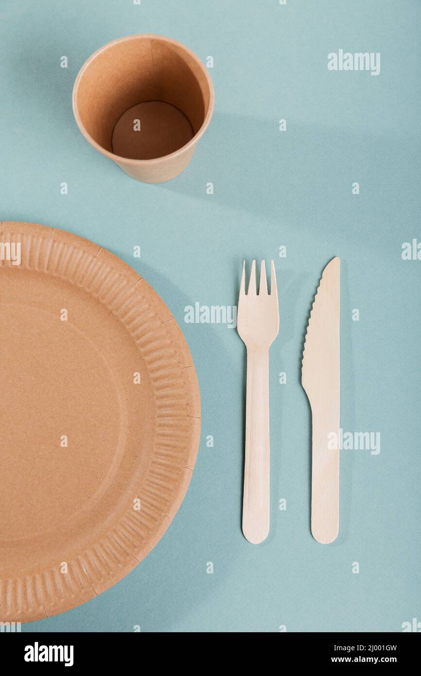 Disposable paper tableware. Cups, plates, wooden forks and knives on ...