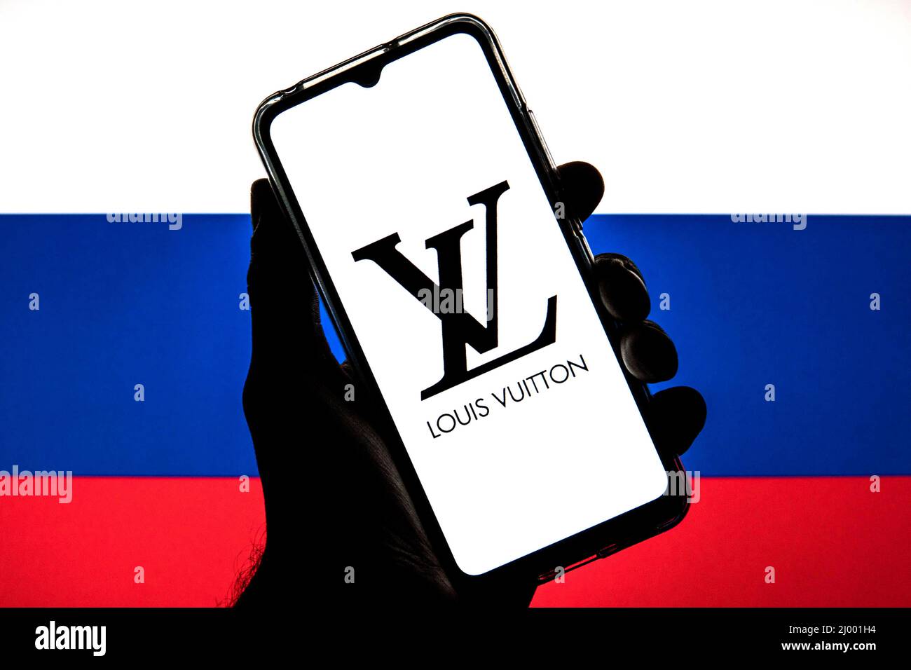 In this photo illustration a Louis Vuitton logo seen displayed on a ...