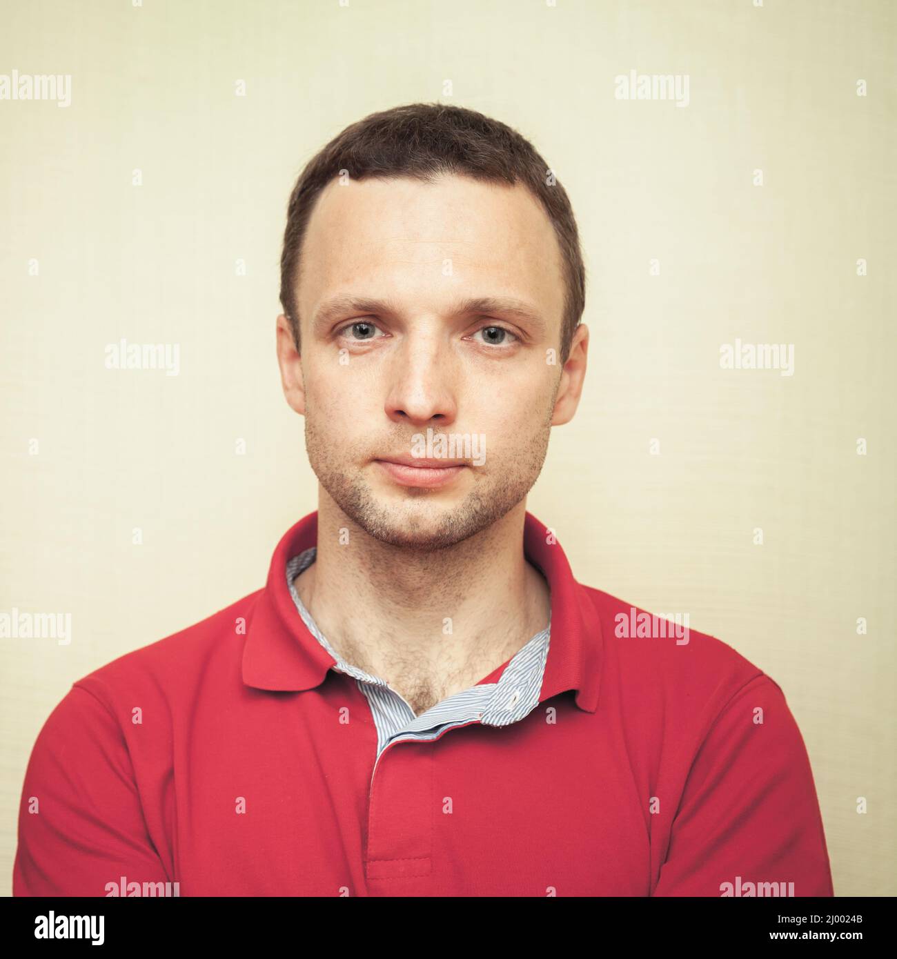 Face studio portrait of young adult European man in red polo shirt ...