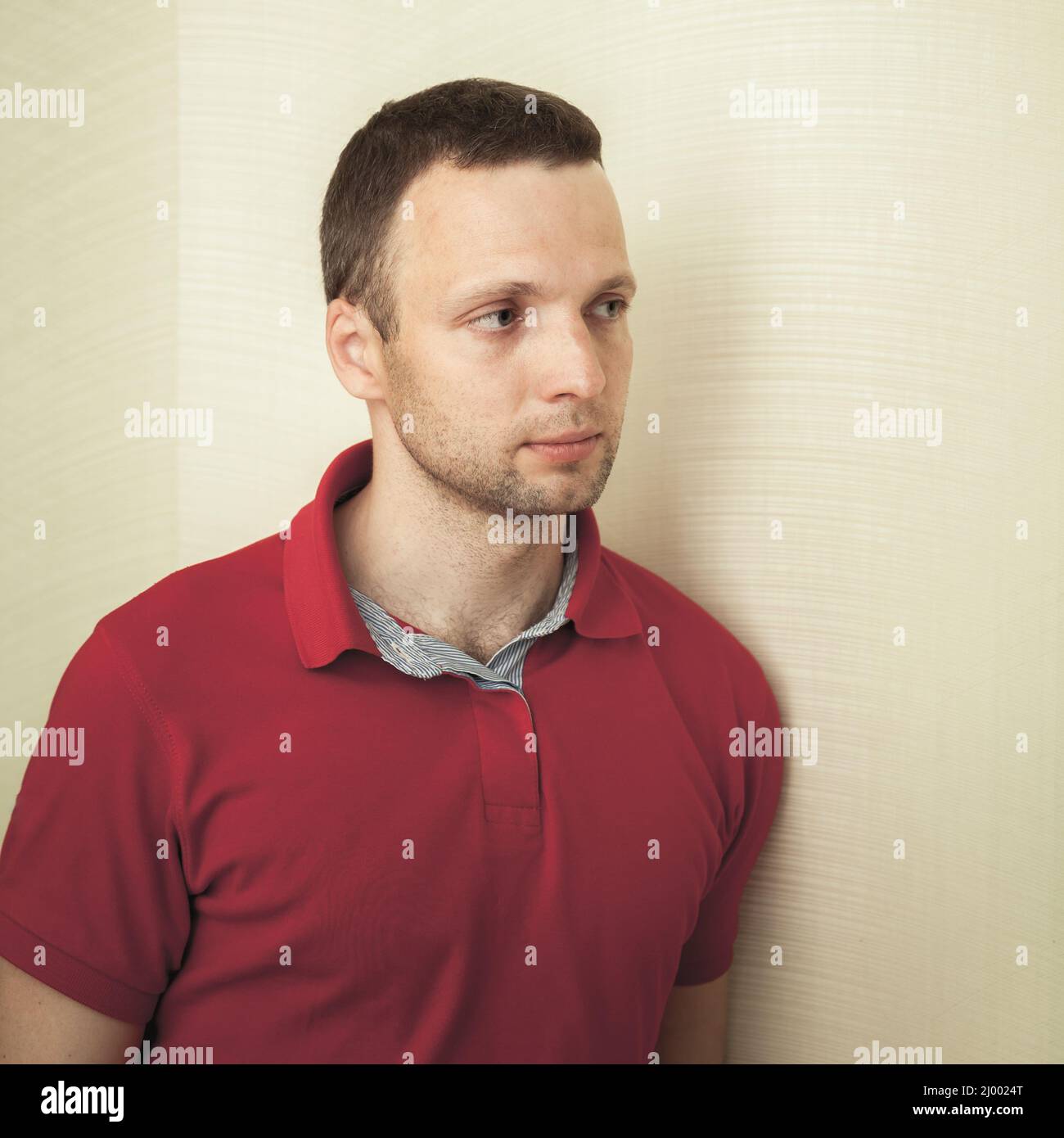 Face studio portrait of young European man in red polo shirt, square ...
