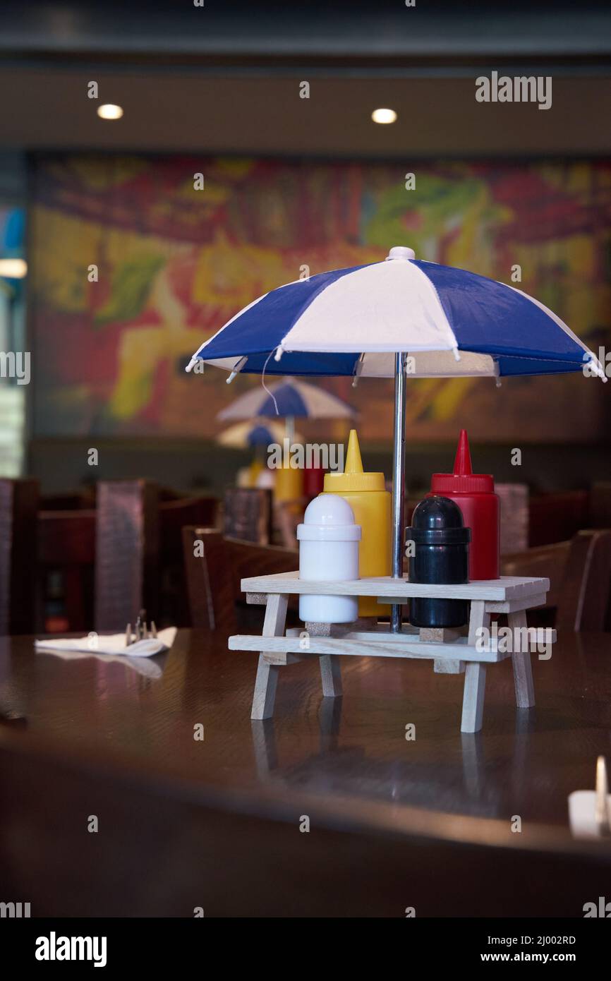 Sauce stand with an umbrella on a restaurant table Stock Photo - Alamy