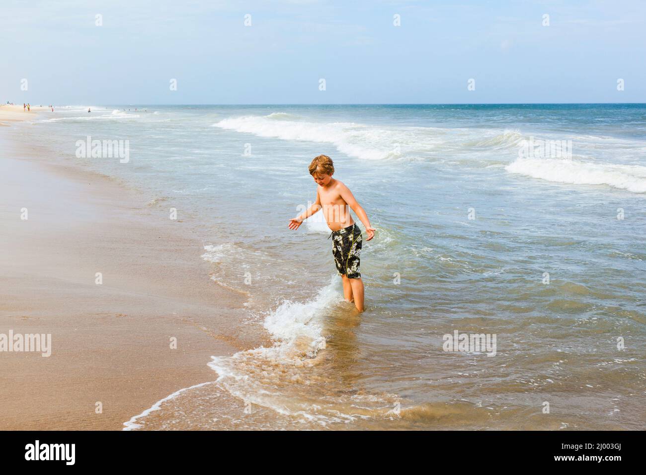 Teen boy standing in the sea waves hi-res stock photography and images ...