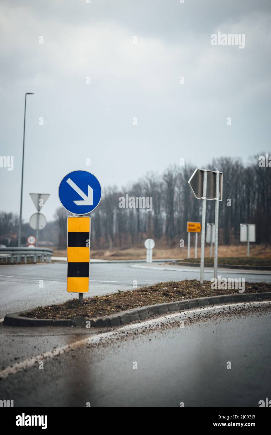 Road with street signs on a gloomy day Stock Photo - Alamy