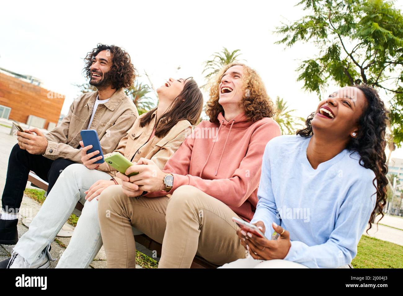 Happy friends using phones and laughing. People and technology having ...