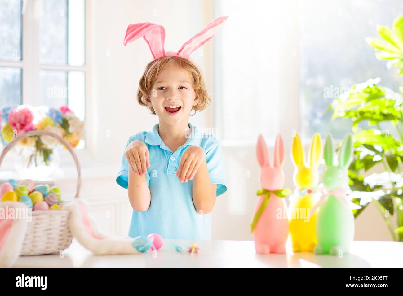 Kids dyeing Easter eggs. Children in bunny ears dye colorful egg for ...