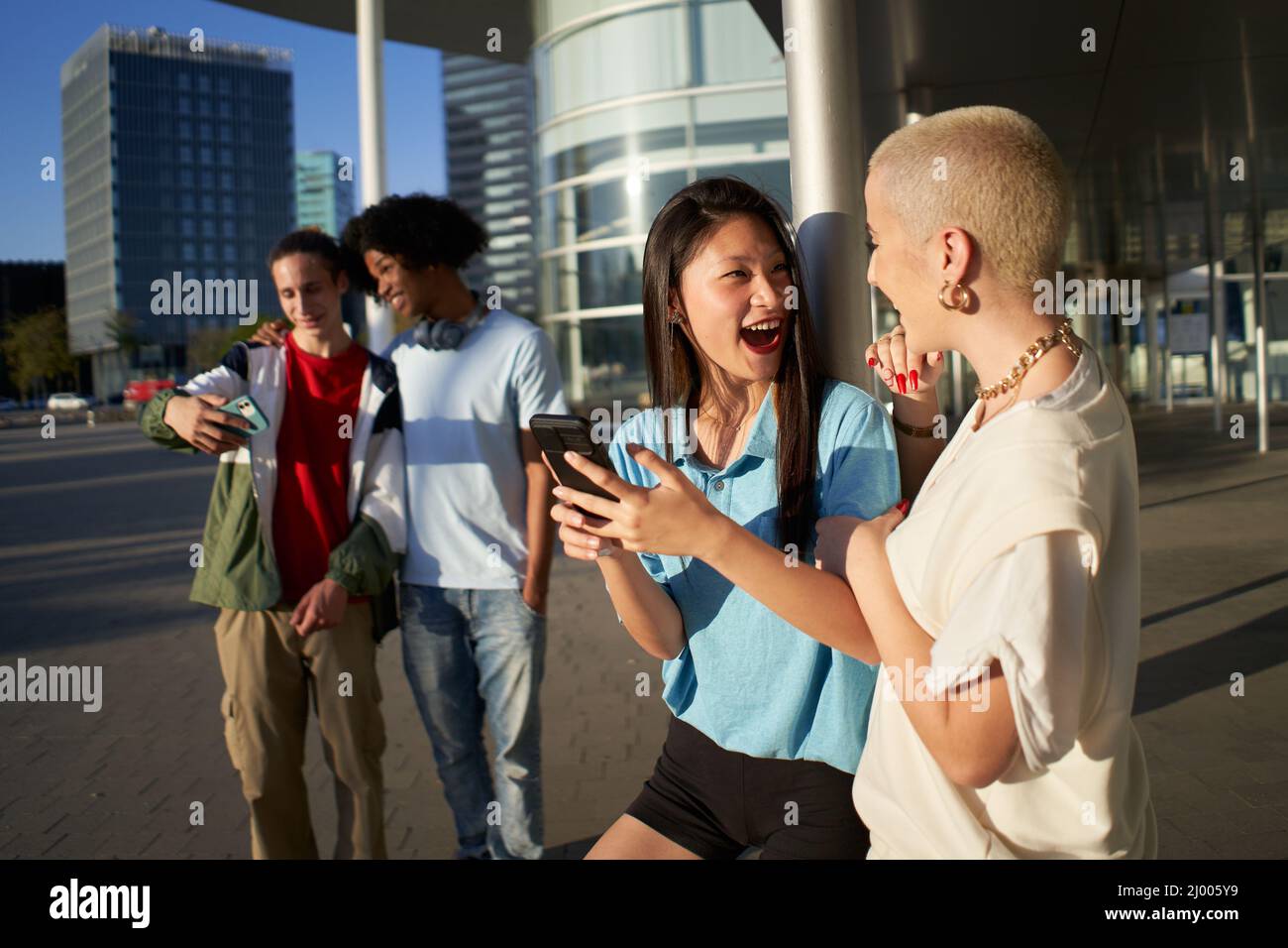 Multiracial people having fun together watching cell phone screens ...